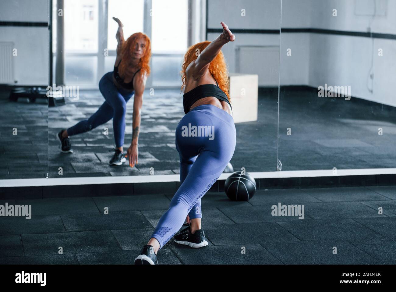Photo in motion. Sporty redhead girl have fitness day in gym at daytime ...