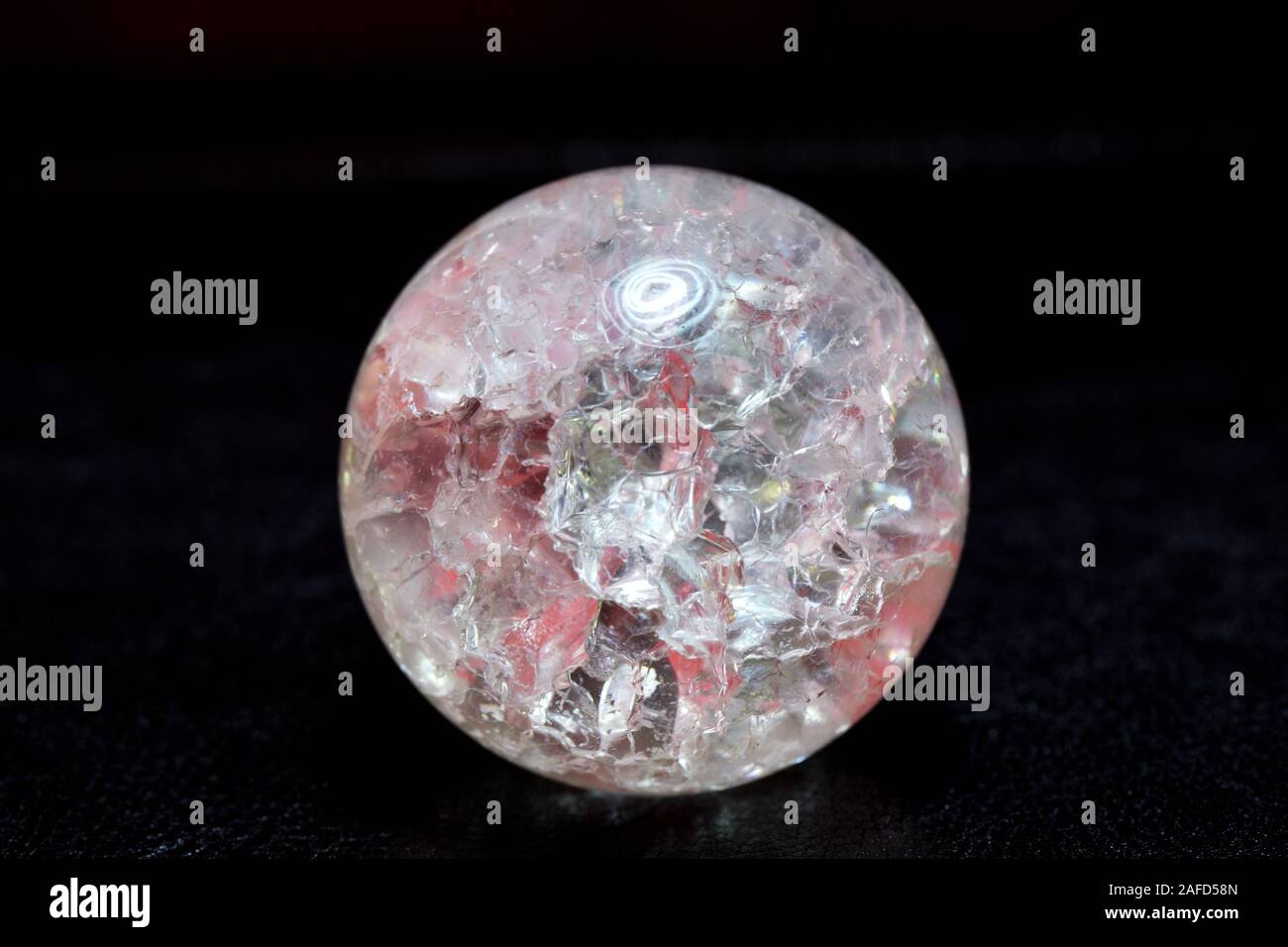 Glowing crystal ball with cracks inside on a dark background. The ...