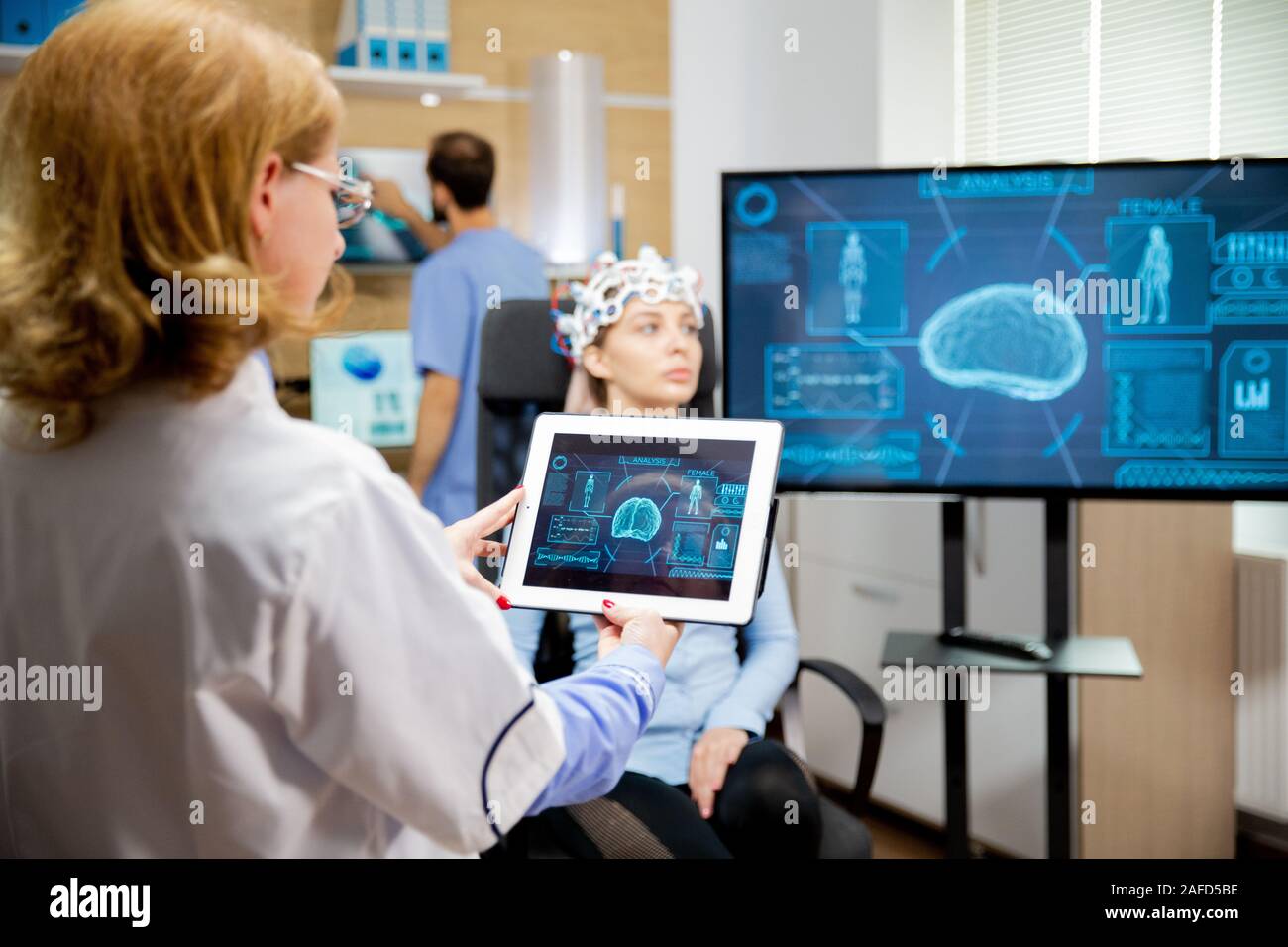 Doctor tracking the evolution of the patient's brain on the tablet ...