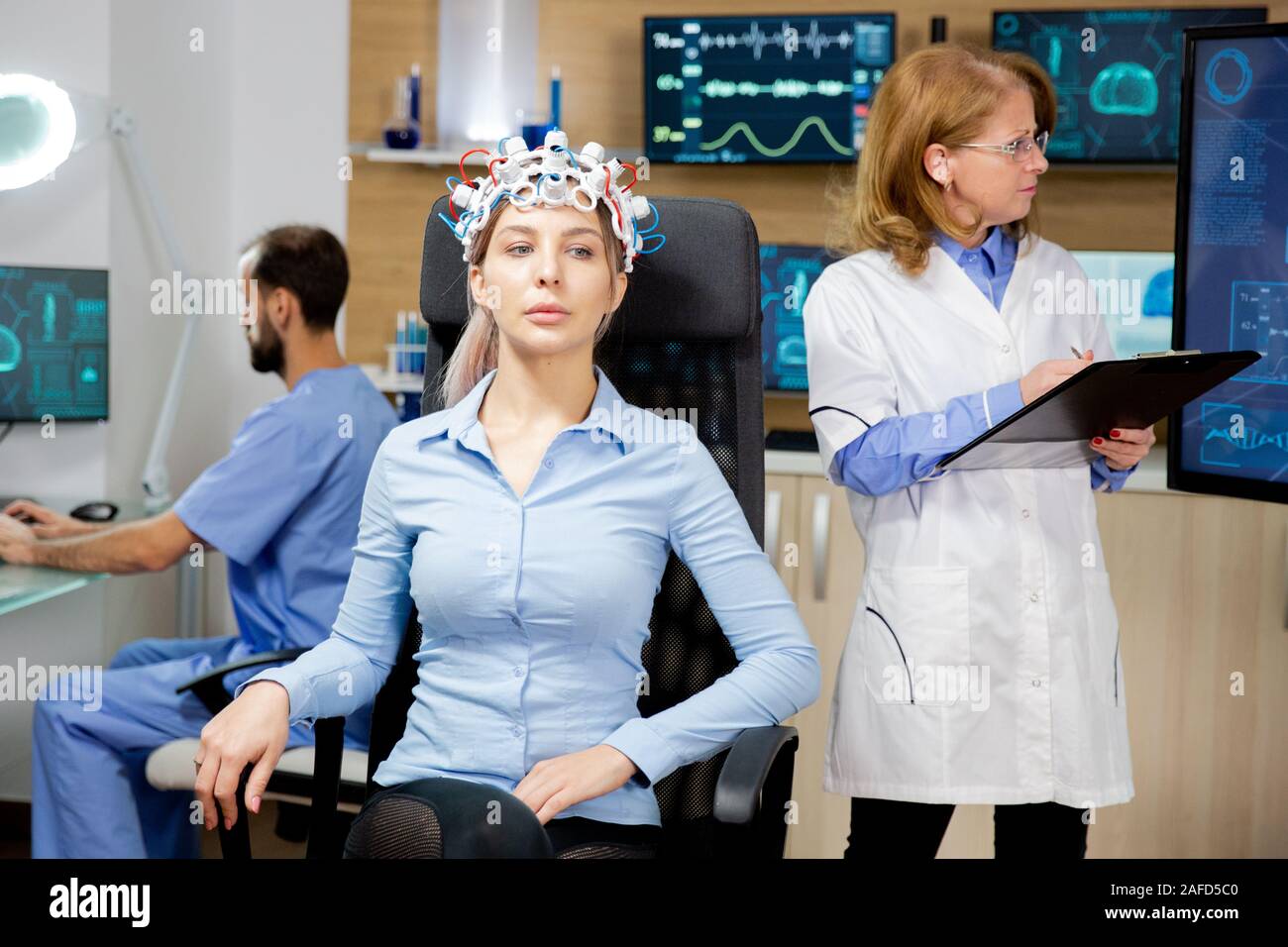 Female patient who is concentrated during a brain wave scanning device ...