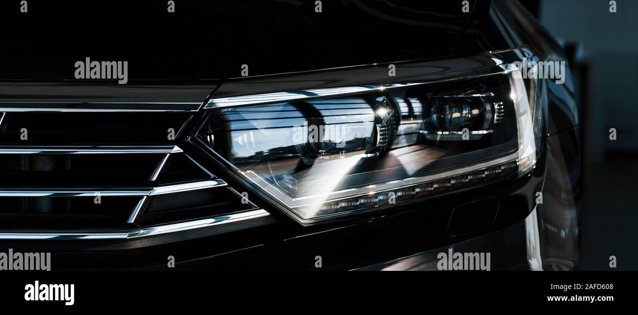 Front part of brand new modern car. Parked at showroom. Reflection in ...