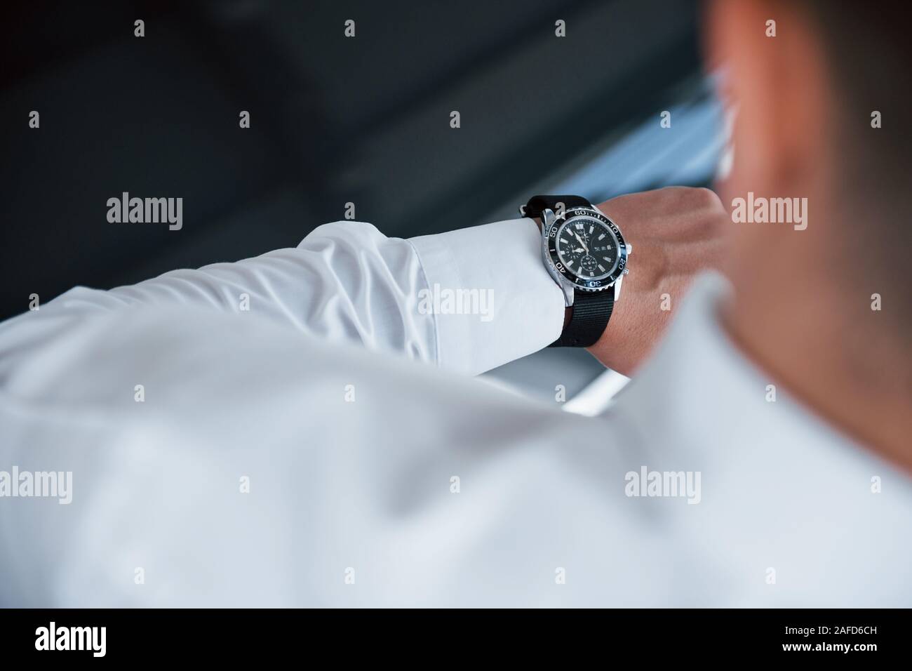 Checks time. Close up photo of man's hand in suit with luxury watch ...