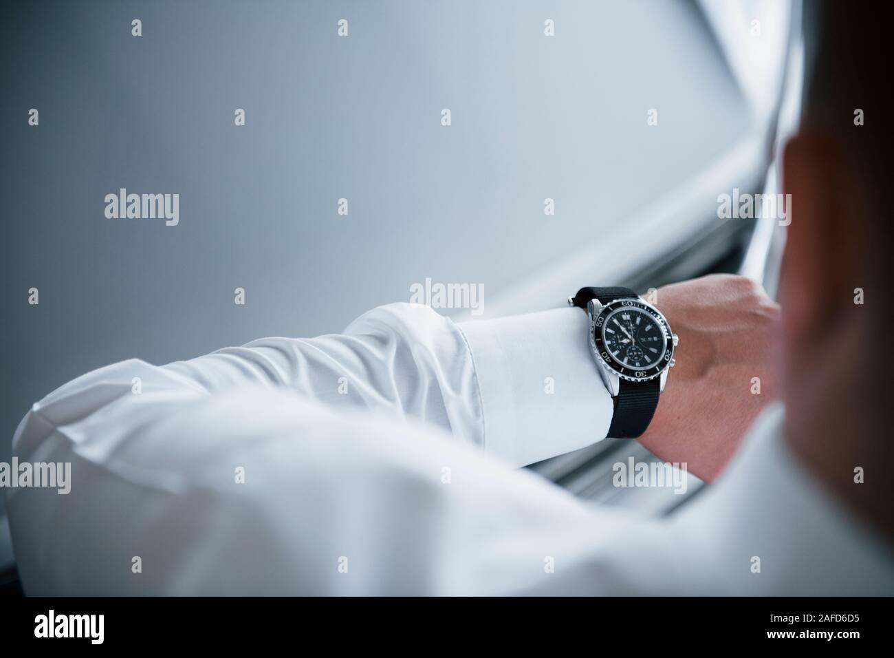 Close up photo of man's hand in suit with luxury watch near the car ...