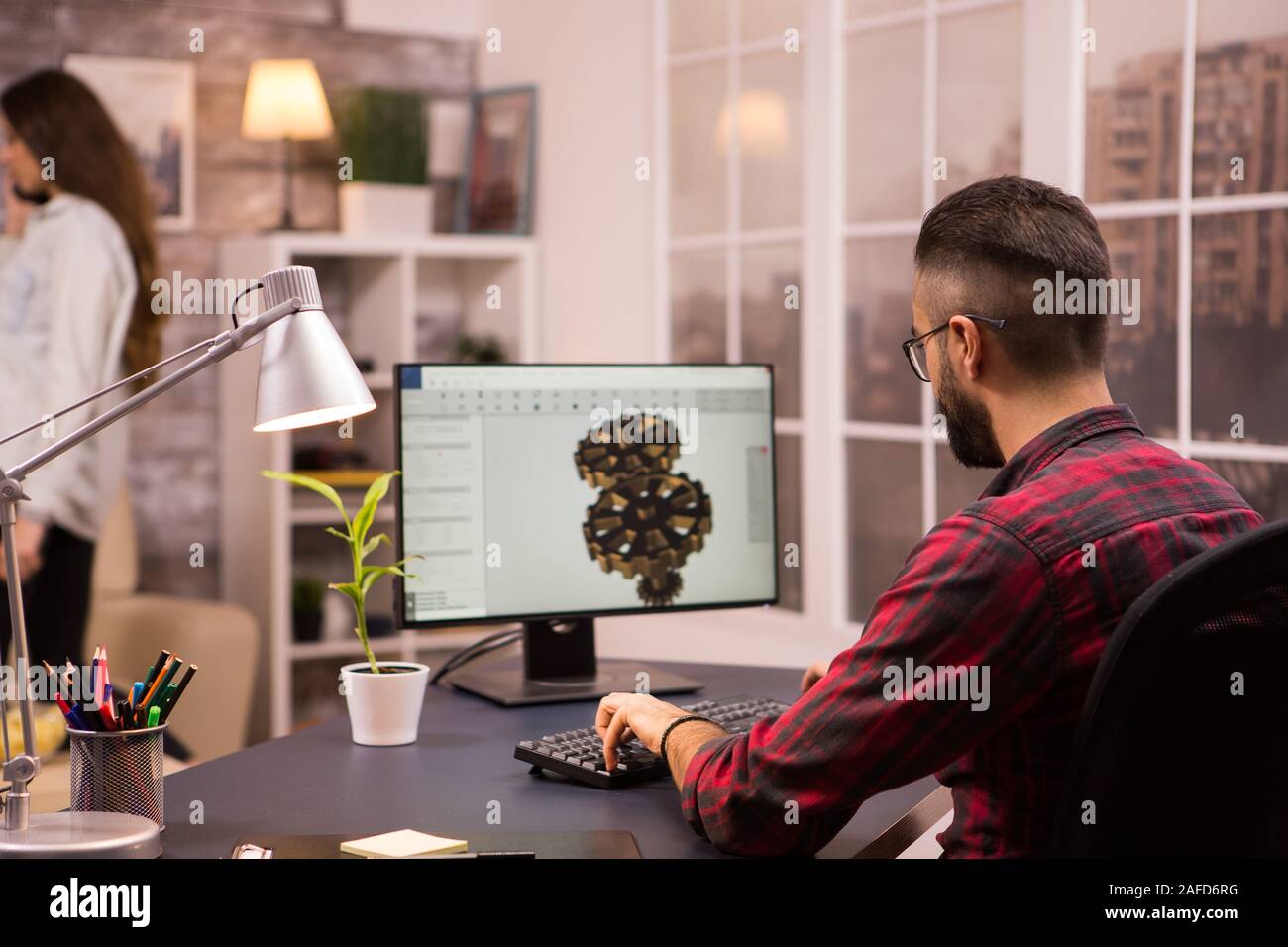 Back view of male engineer drawing a mechanical prototype using cad ...