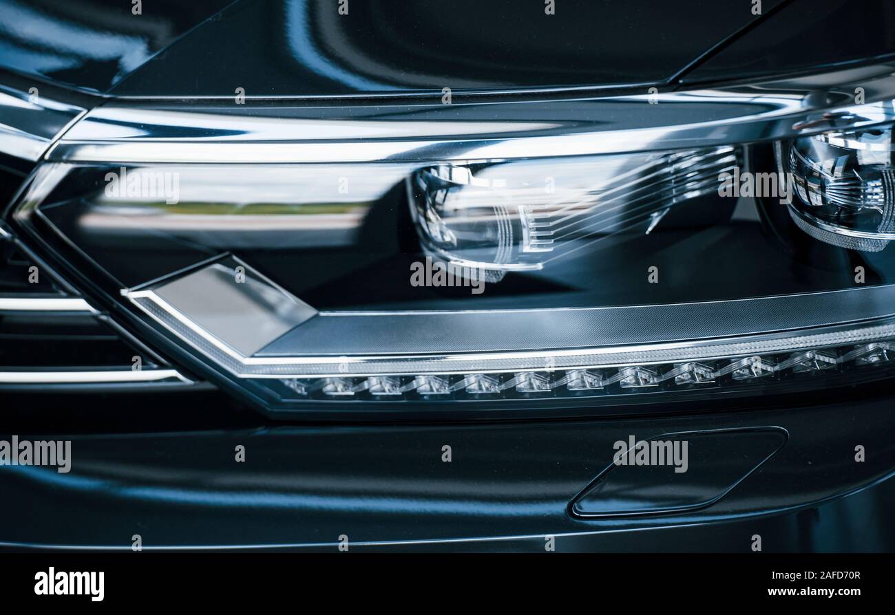 Front part of brand new modern car. Parked at showroom. Reflection in ...