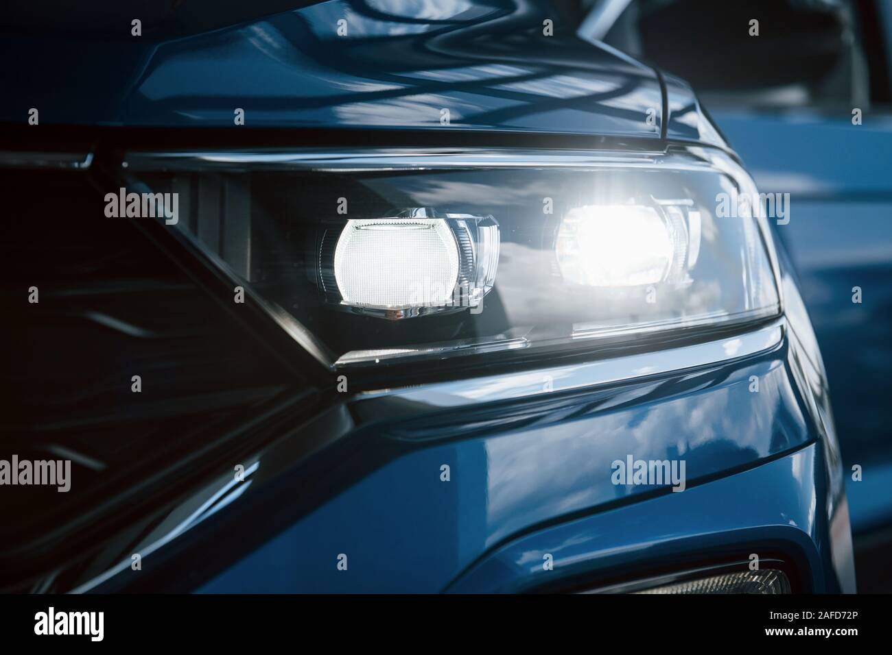 Front part of brand new modern blue car. Parked at showroom. Reflection ...