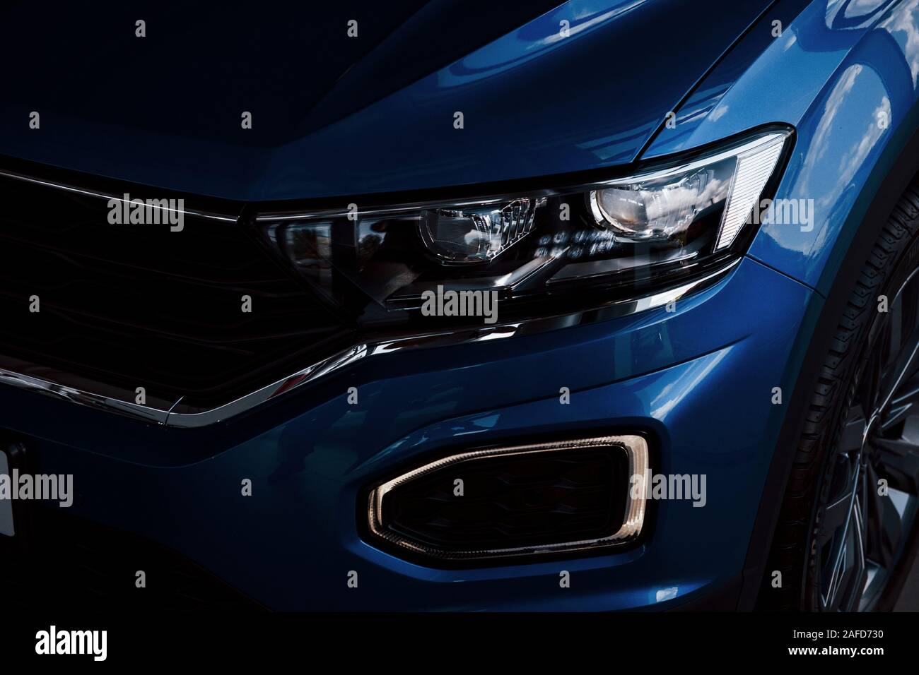 Front part of brand new modern blue car. Parked at showroom. Reflection ...