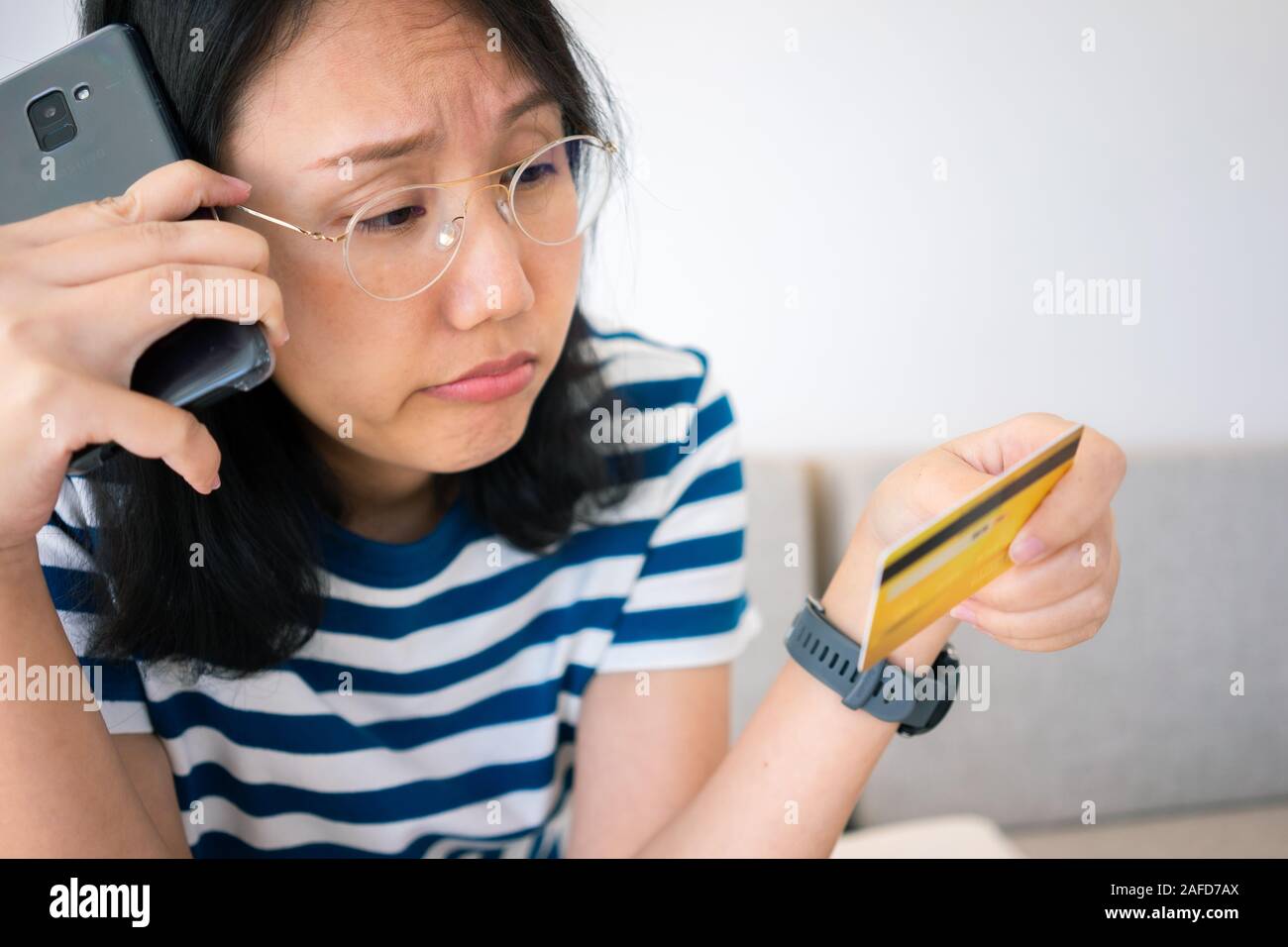 Confused portrait young woman holding credit cards having problem ...