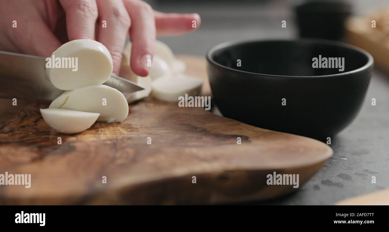 Man cutting small mozzarella balls on olive wood board, wide photo ...