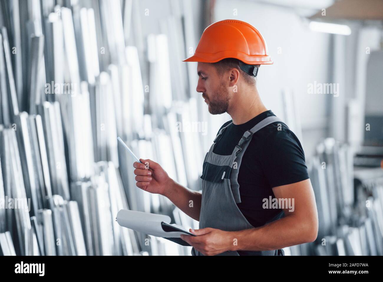 Counting and checking objects in the storage. Industrial worker indoors ...