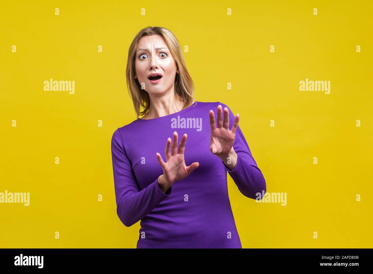 I'm afraid! Portrait of panicked scared woman in tight purple dress ...