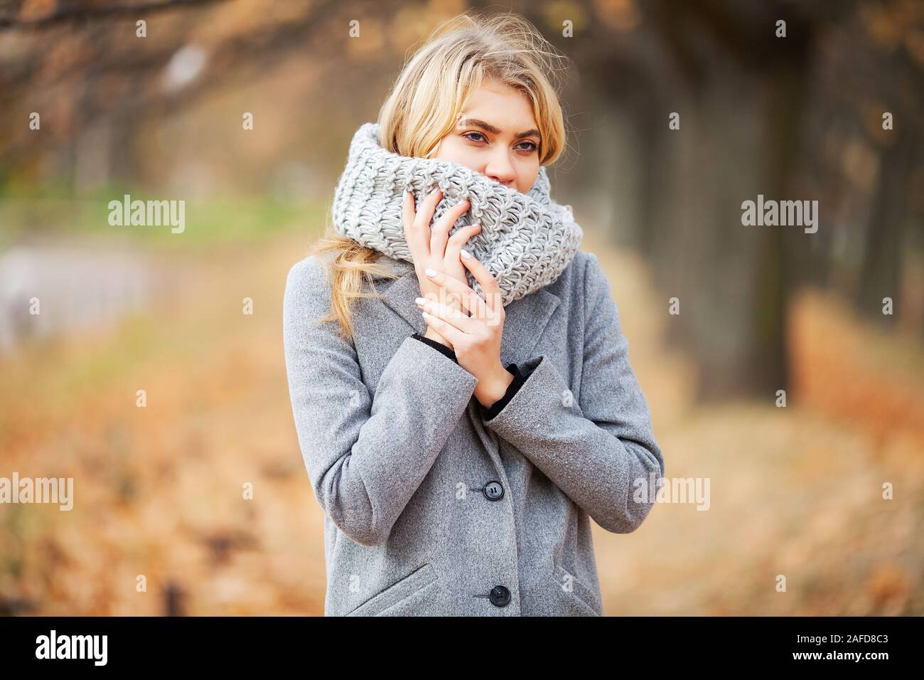 Cold autumn. Woman walking in park feeling cold Stock Photo - Alamy