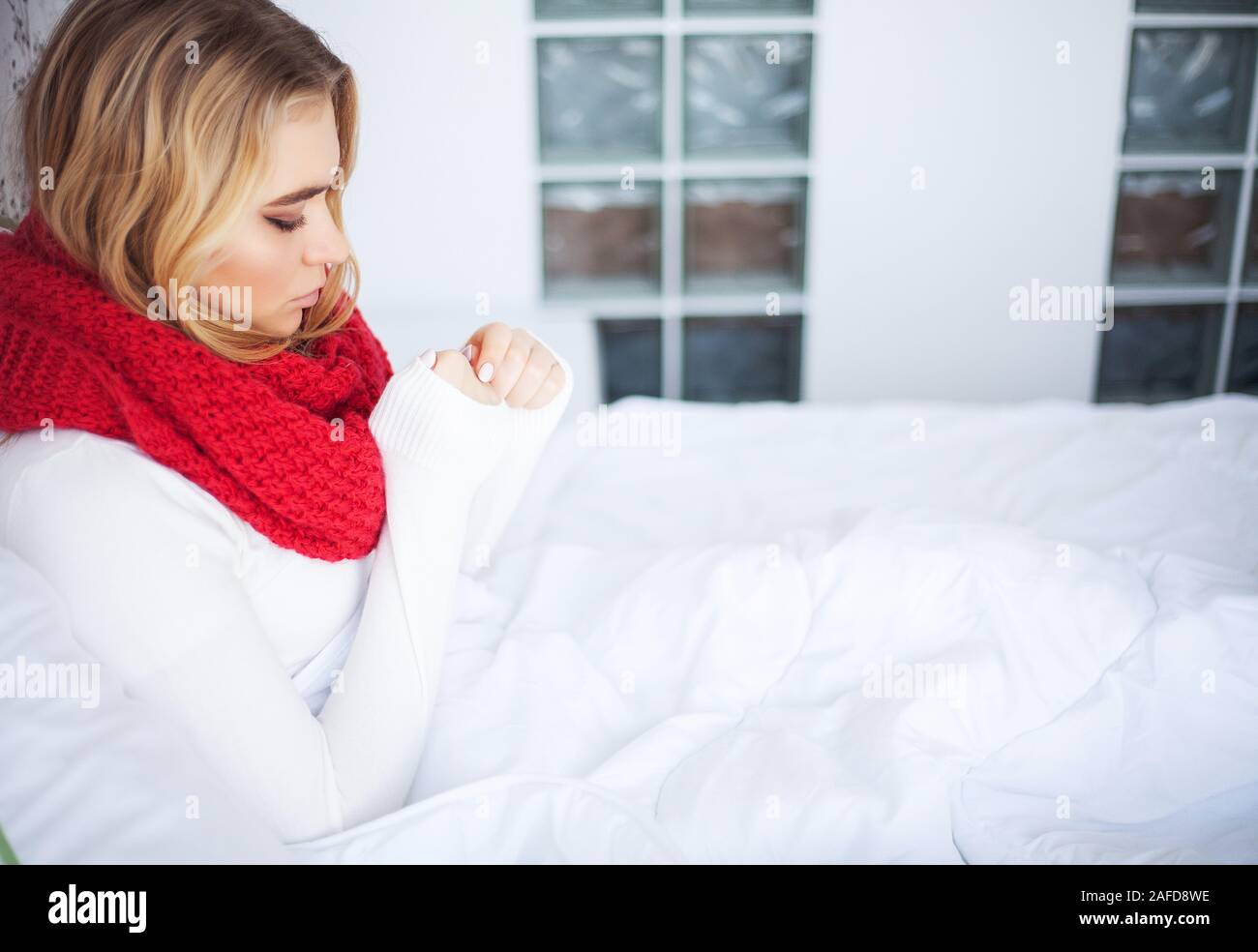 High temperature. Sick woman sitting under a blanket Stock Photo - Alamy