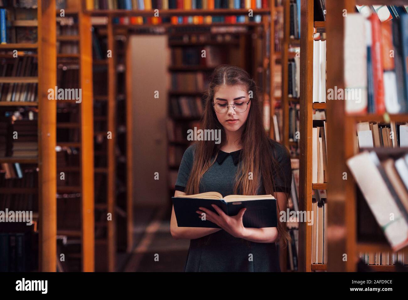 Reading interesting book. Female student is in library. Conception of ...