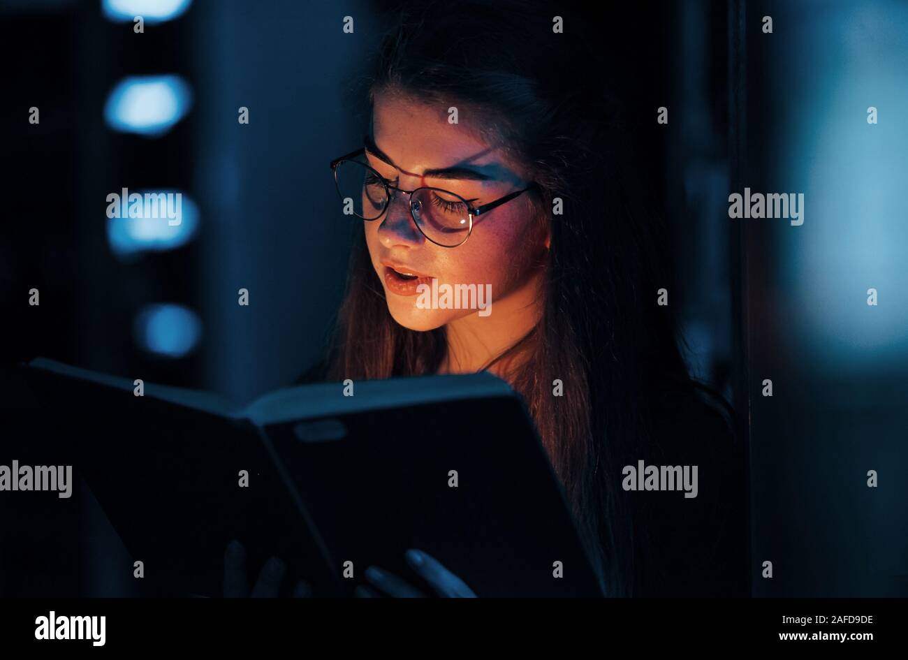 Light goes from the book. Female student is in library. Conception of ...