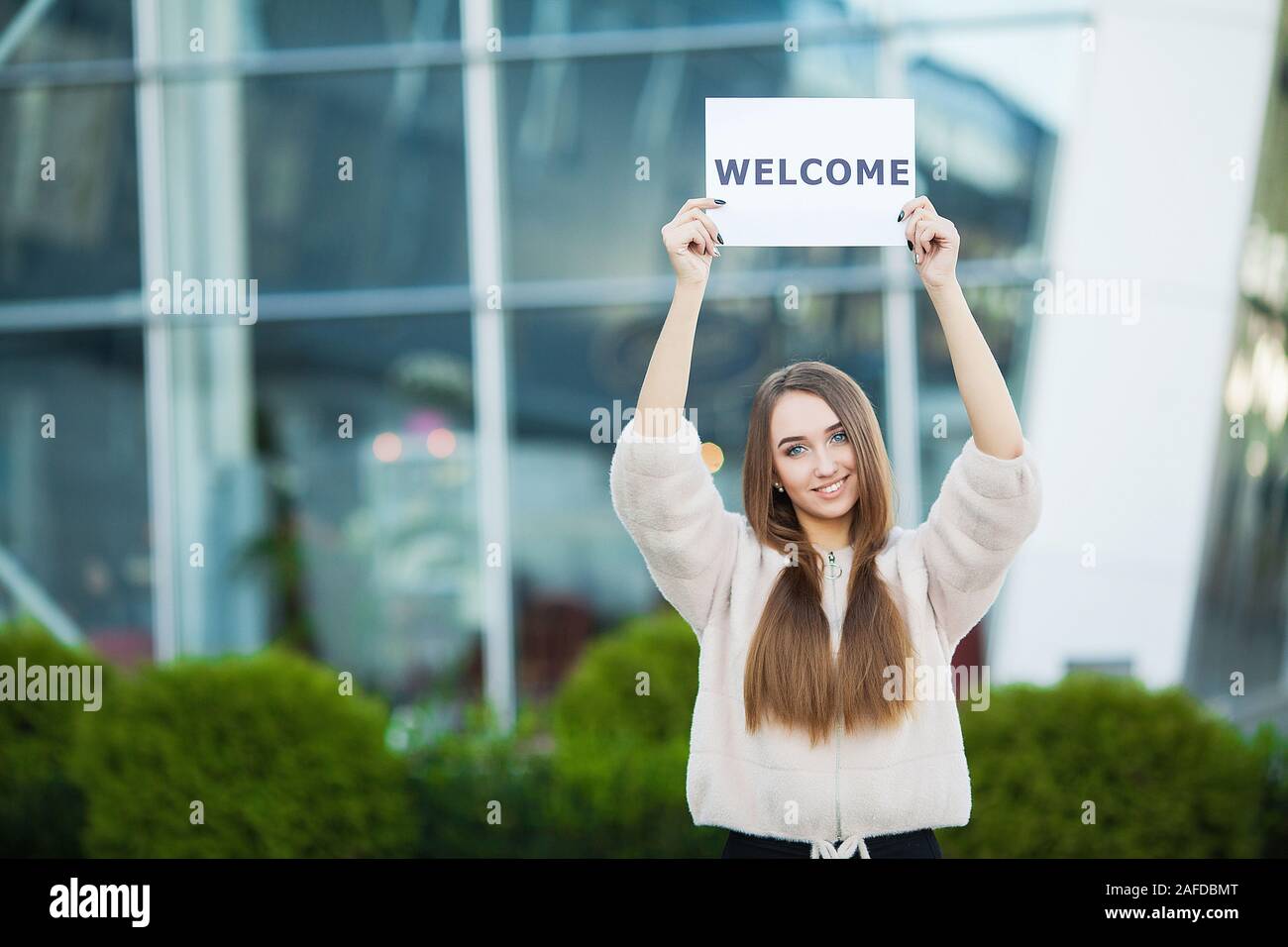 Women business with the poster with welcome message Stock Photo - Alamy