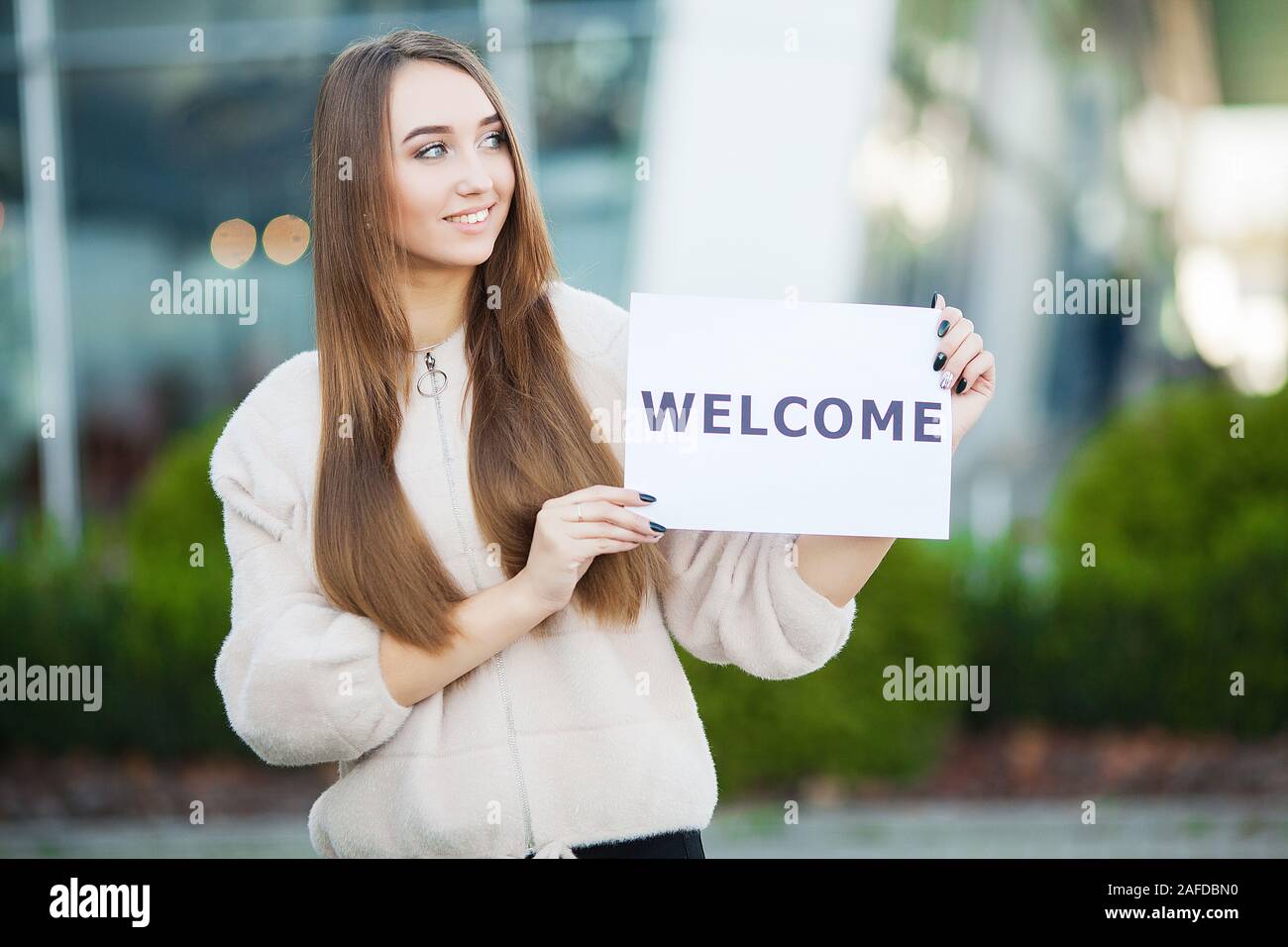 Women business with the poster with welcome message Stock Photo - Alamy