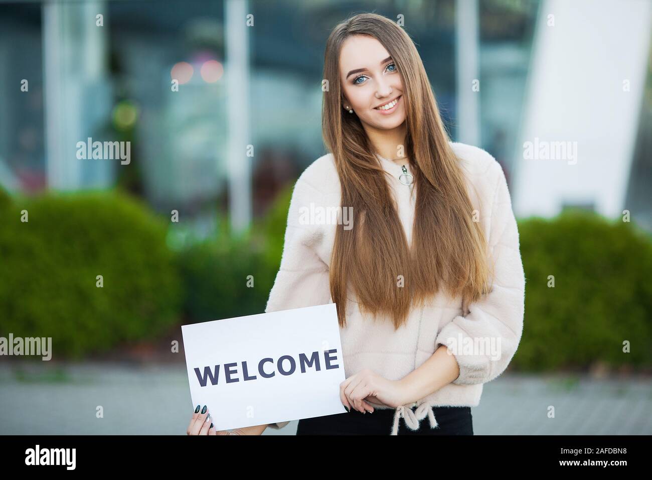 Women business with the poster with welcome message Stock Photo - Alamy