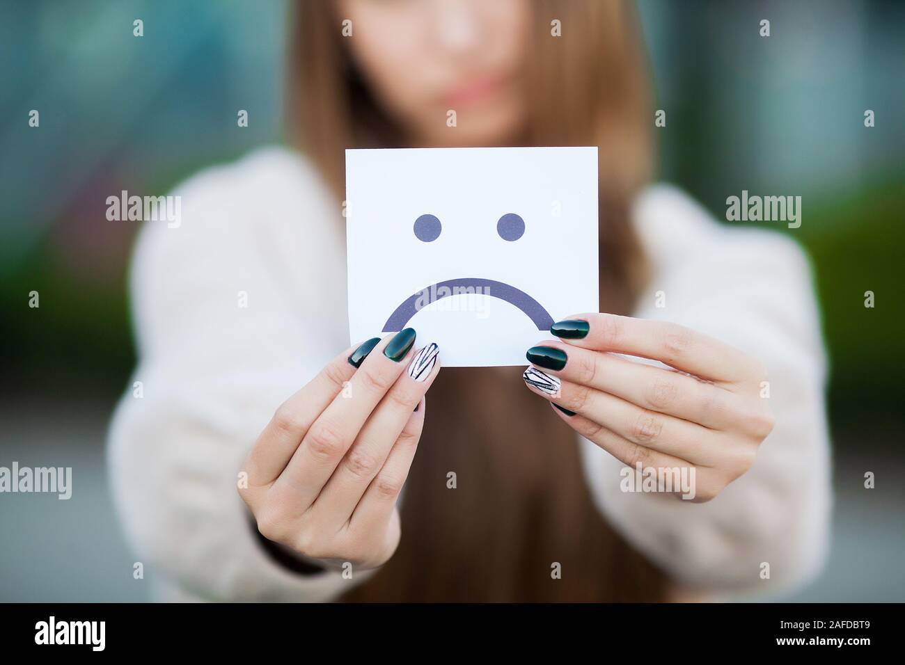 Beautiful woman holding card with sad smile Stock Photo - Alamy