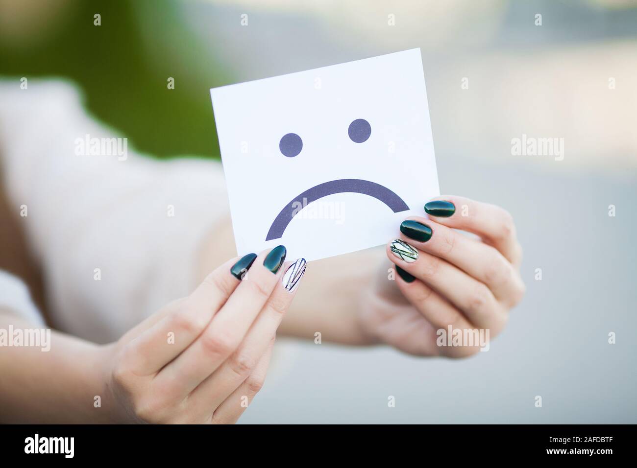 Beautiful woman holding card with sad smile Stock Photo - Alamy