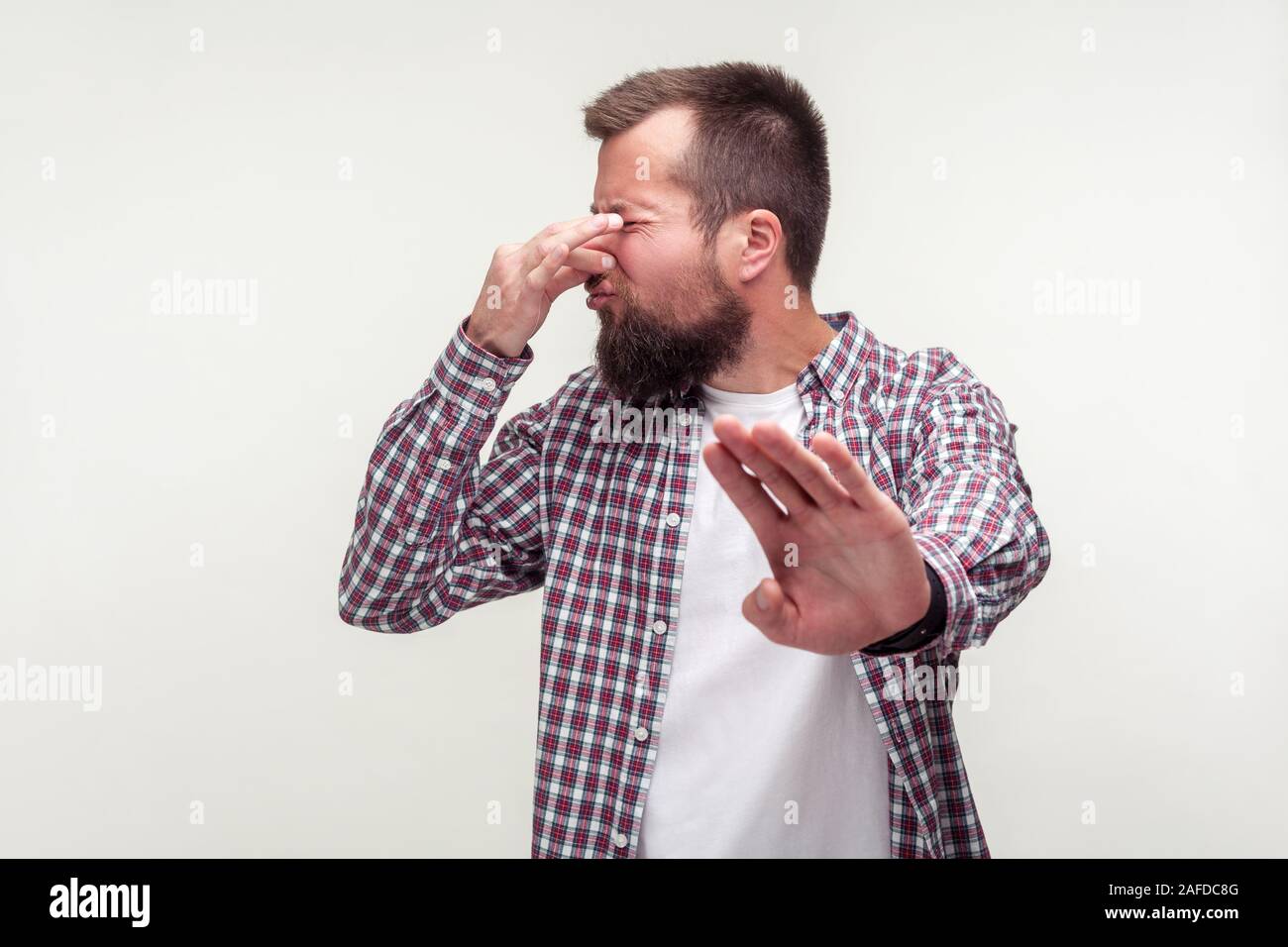 Portrait of confused bearded man in casual plaid shirt showing stop ...