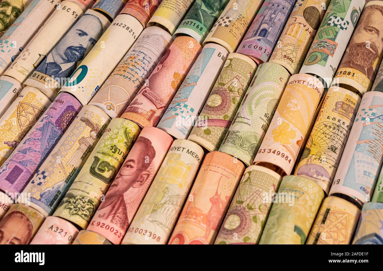 Different colourful banknotes from various countries on rolls to be ...