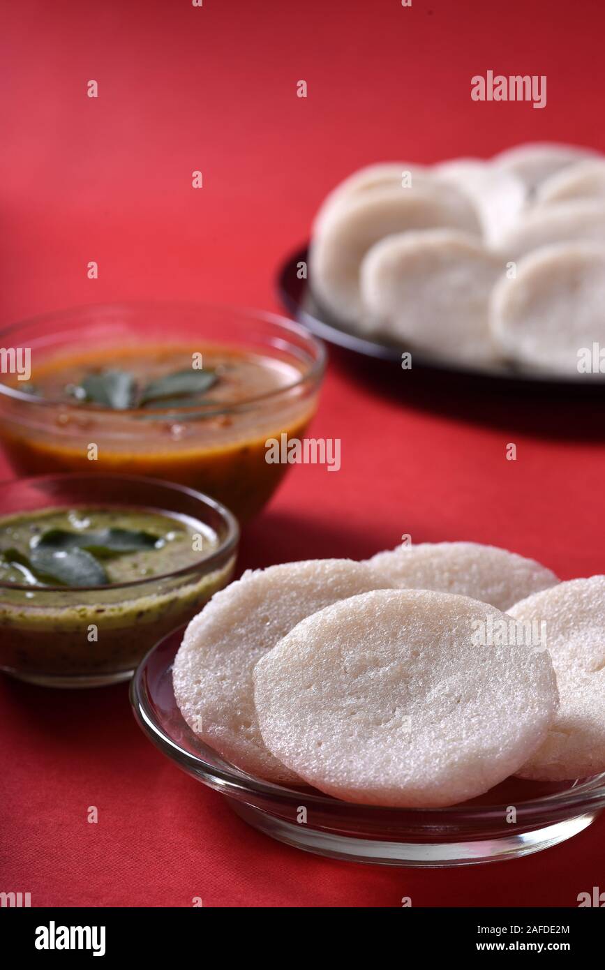 Idli with Sambar and coconut chutney on red background, Indian Dish ...