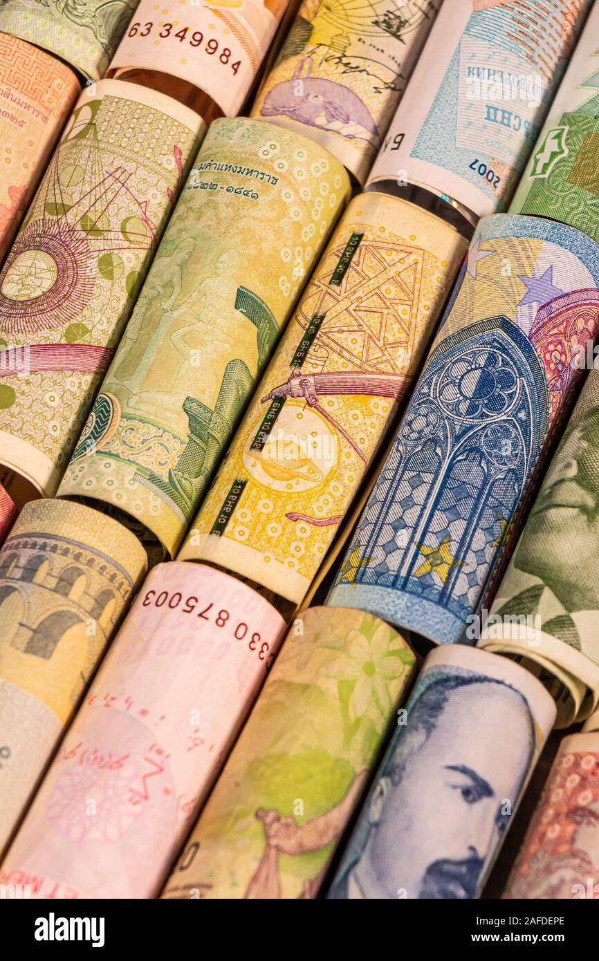 Different colourful banknotes from various countries on rolls to be ...