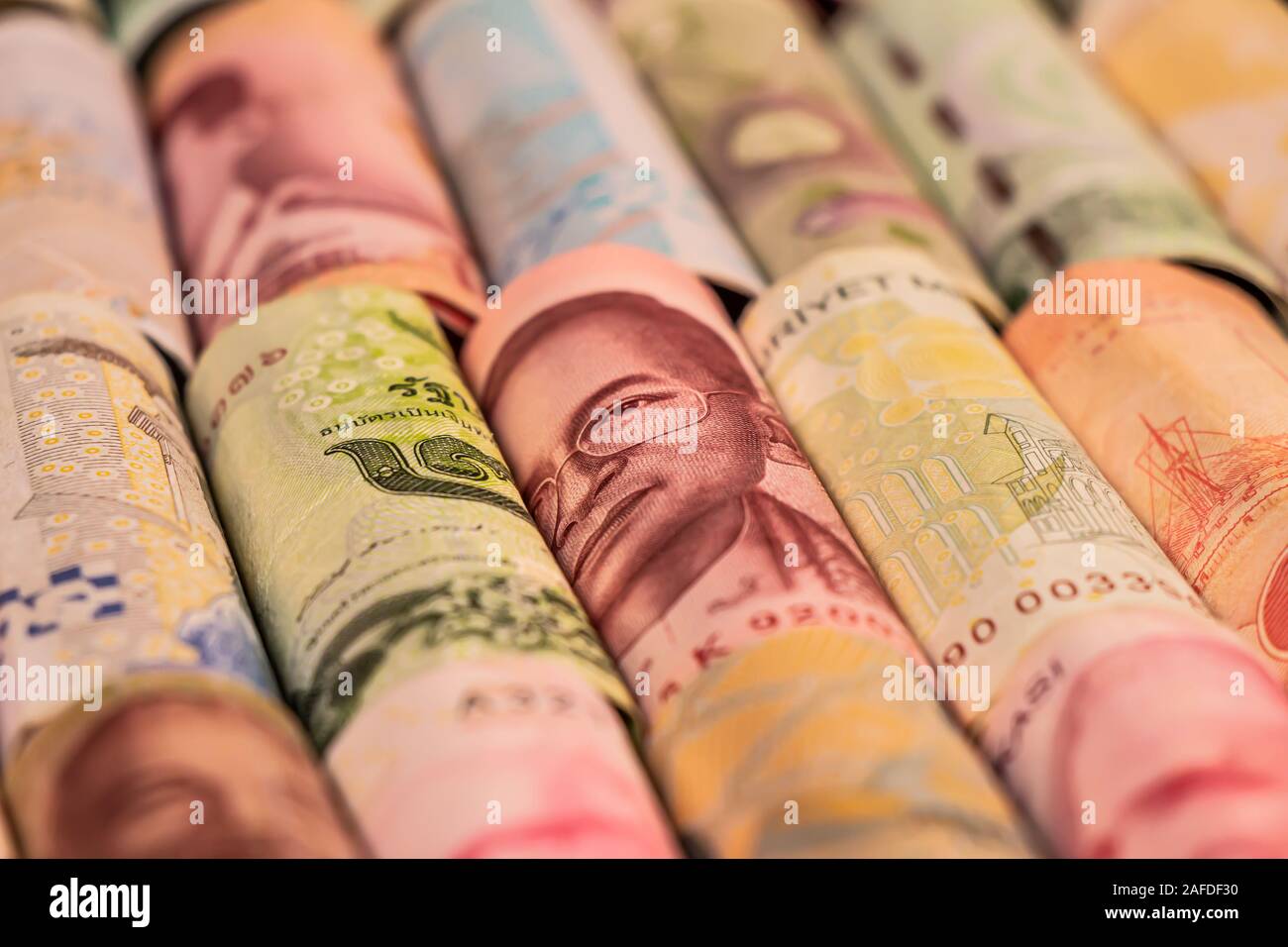 Different colourful banknotes from various countries on rolls to be ...