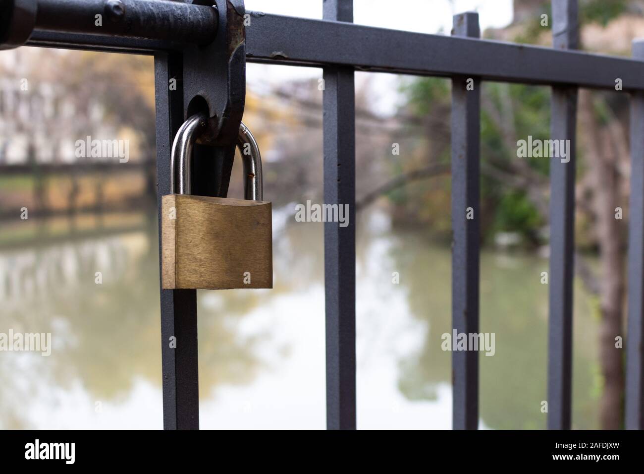 close-up of a lock on a gate with river background on a cloudy day ...