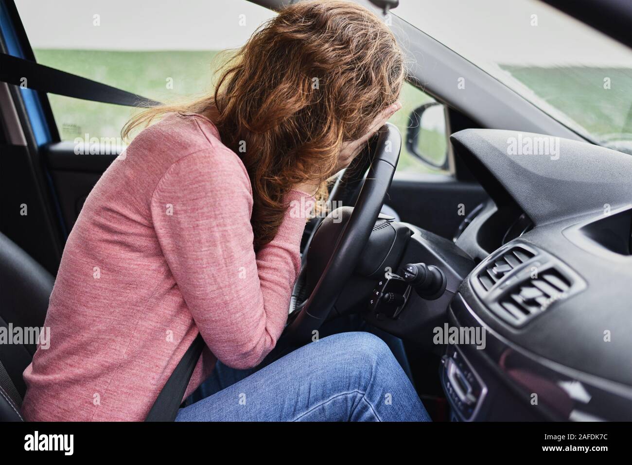 Stressed woman covering face with hands in car. Driver panic concept ...
