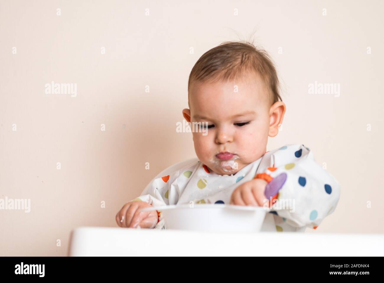 A Little baby eating her dinner and making a mess Stock Photo - Alamy