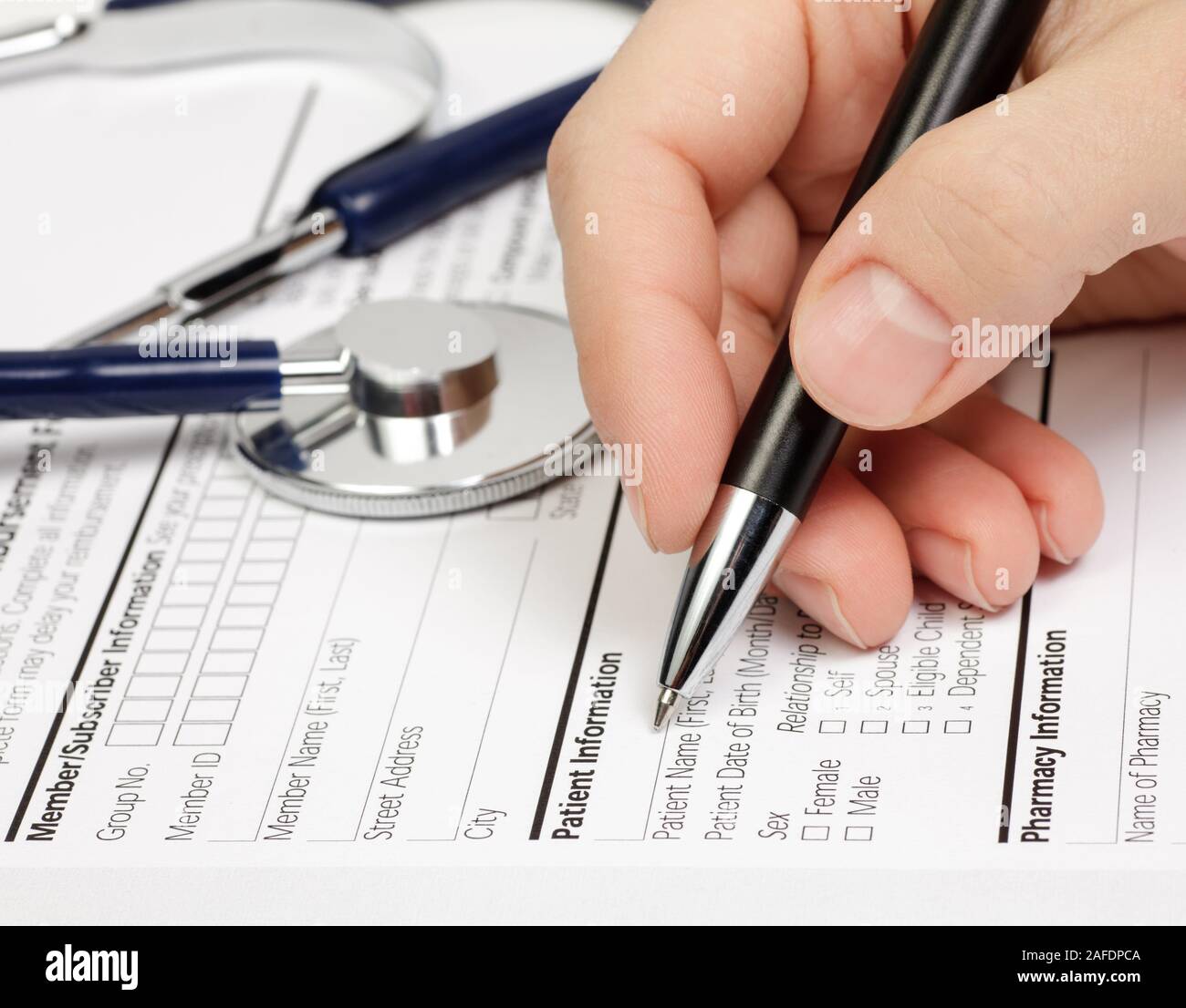 Hand with pen over blank Prescription form with patient information ...