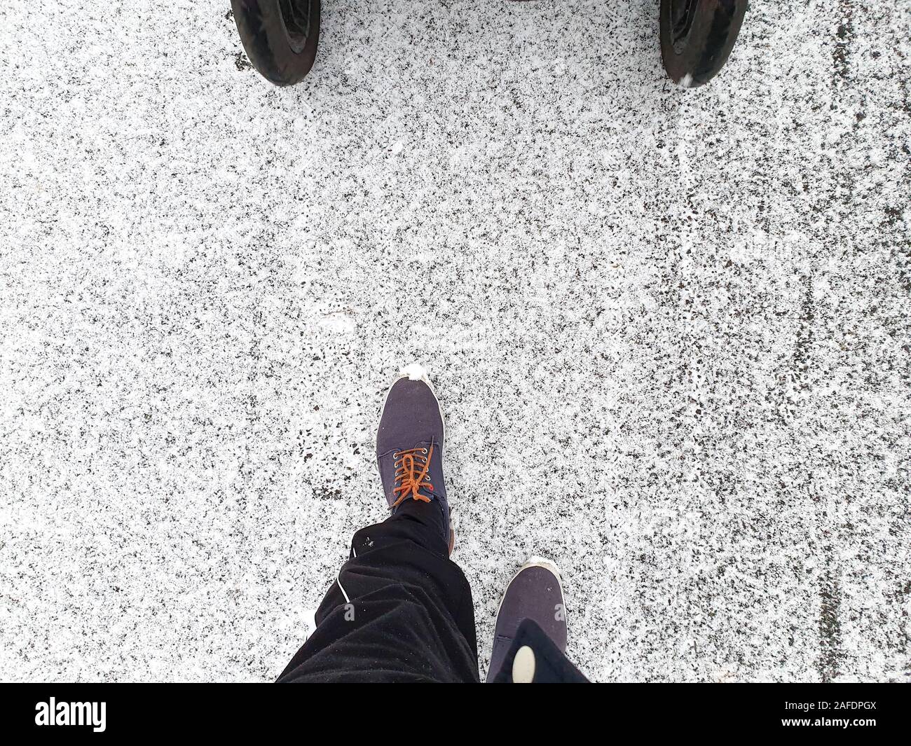 Man standing on a street slightly covered with snow Stock Photo - Alamy