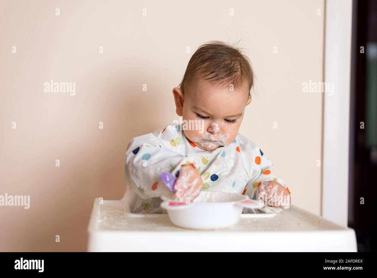 A Little baby eating her dinner and making a mess Stock Photo - Alamy