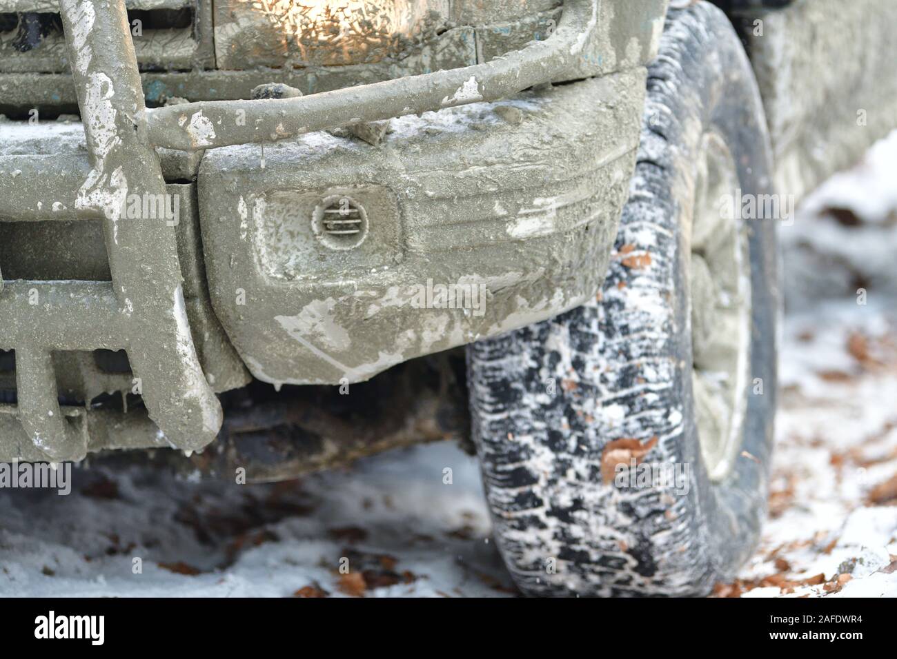 Detail of a dirty wheel, a lit light and a mudguard off-road car in ...