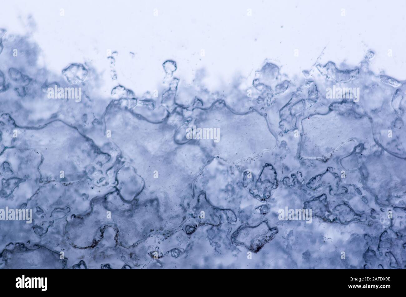 glass in the window covered with wet melting snow, close-up, macro ...
