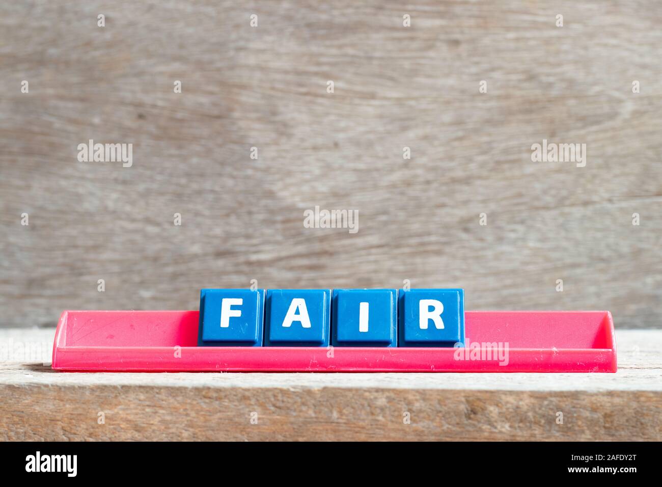 Tile letter on red rack in word fair on wood background Stock Photo - Alamy