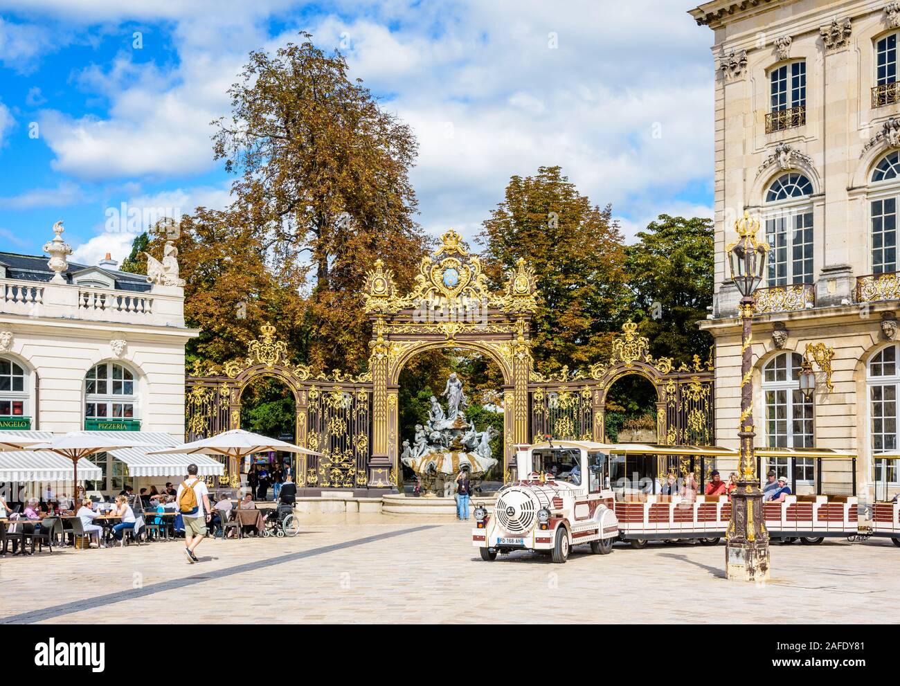 A city tour train on the Stanislas square is driving past the Rococo ...