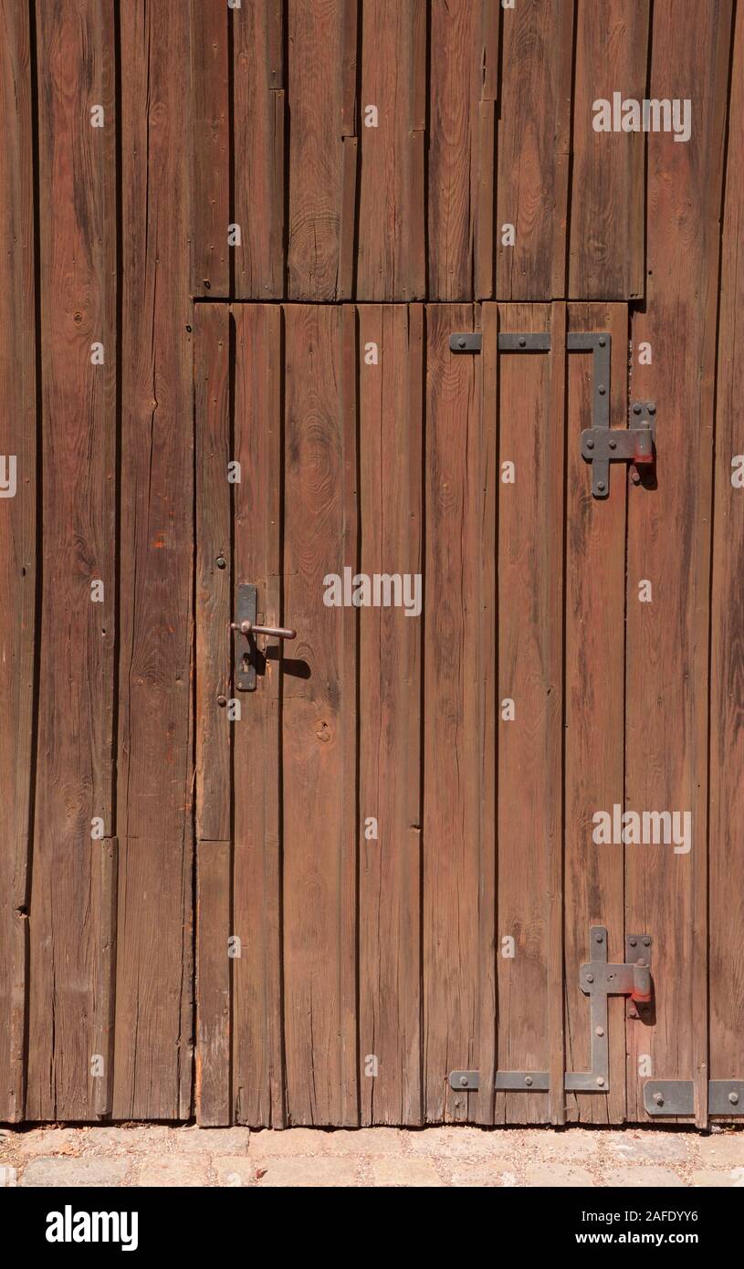 old and nostalgic wooden gate with forged iron hinged patterns in ...