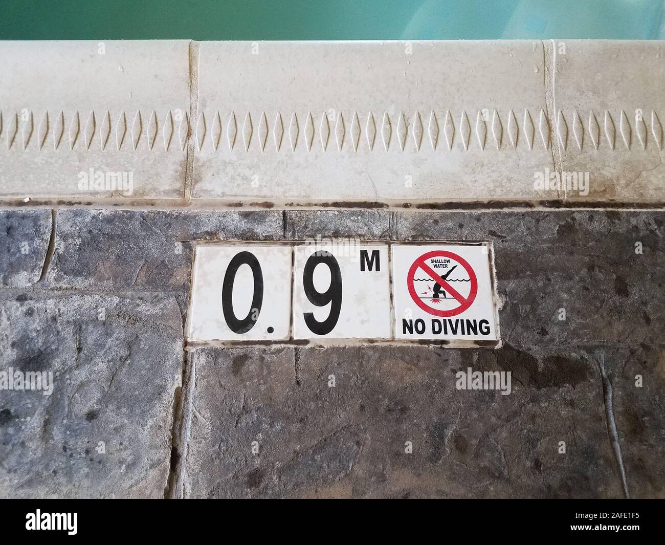 no diving warning sign or symbol at edge of swimming pool Stock Photo ...