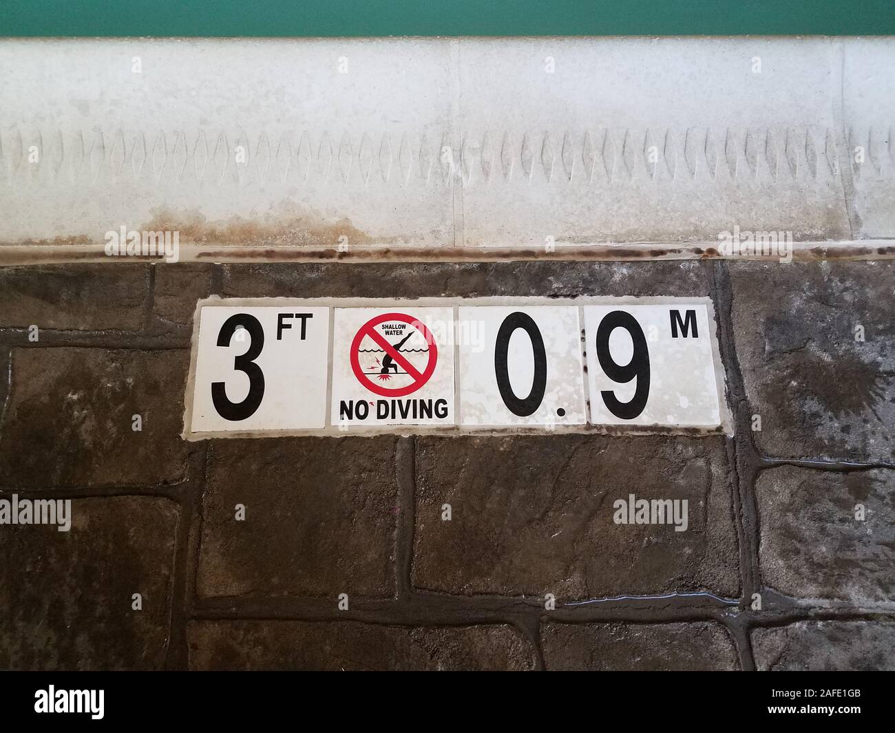 no diving warning sign or symbol at edge of swimming pool Stock Photo ...