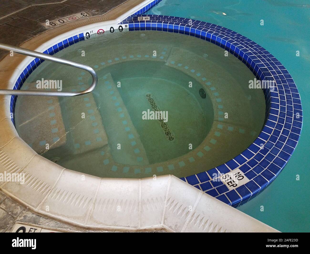 swimming pool with hot tub area and metal railing Stock Photo - Alamy