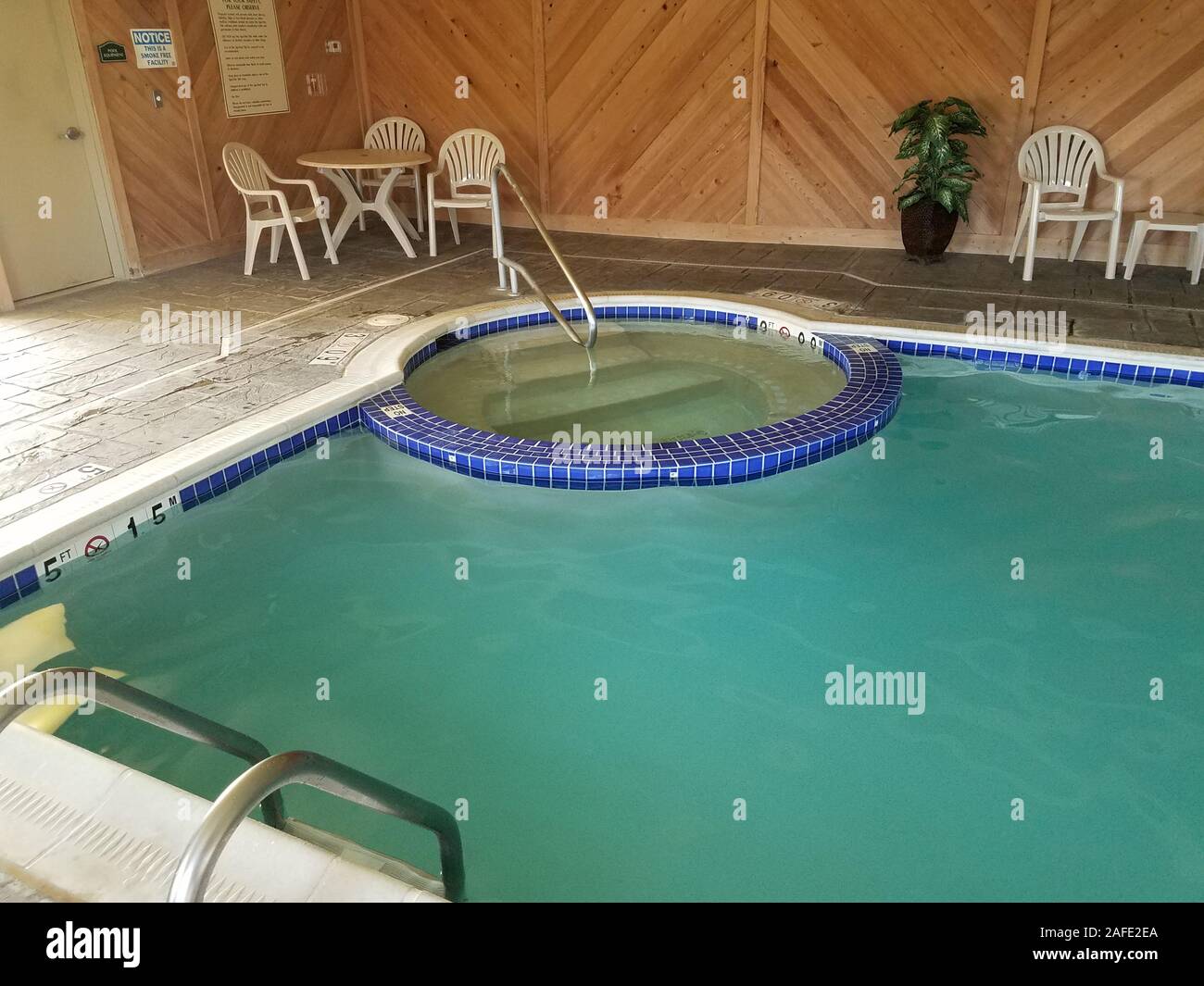 swimming pool with hot tub area and metal railing Stock Photo - Alamy