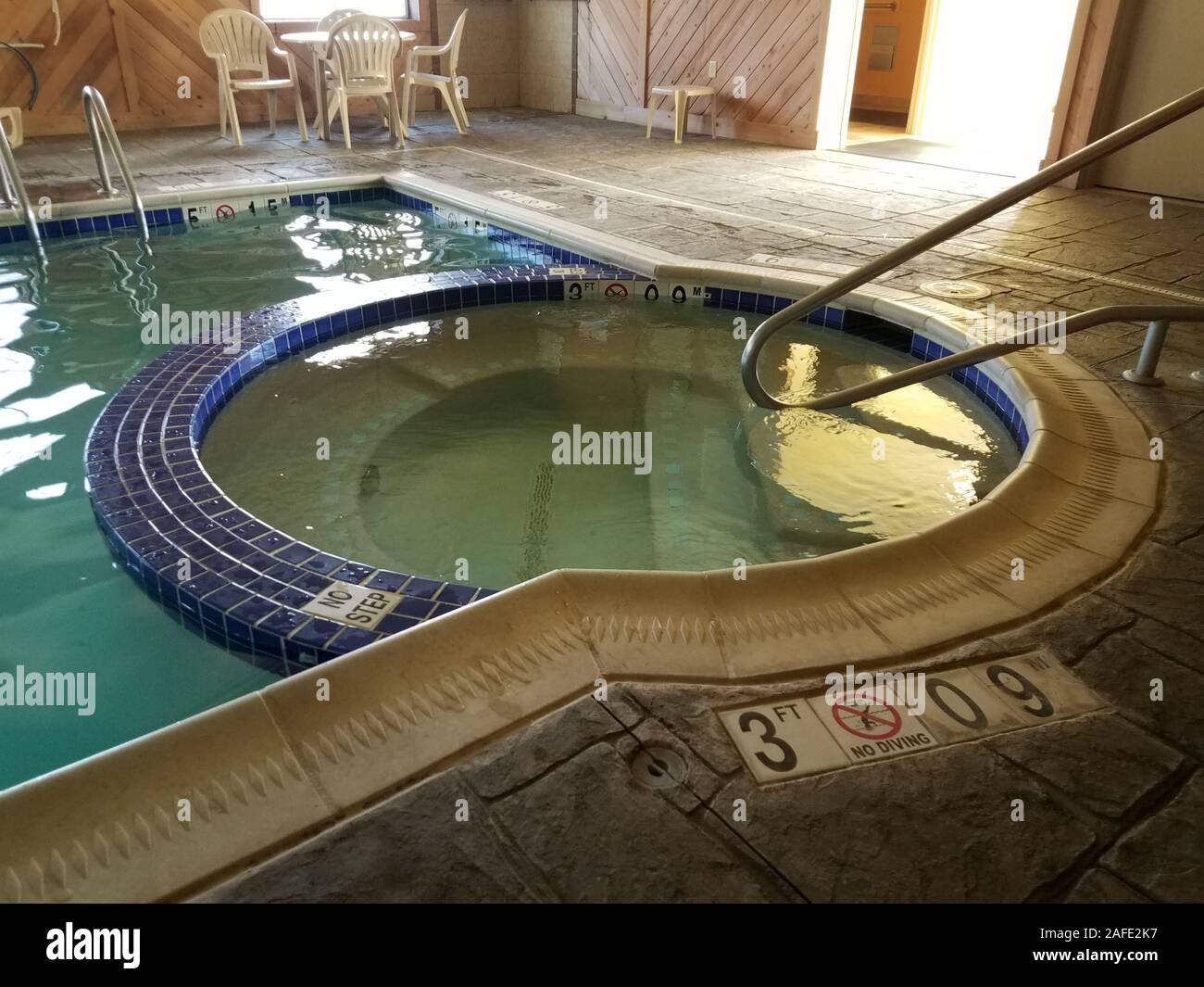 swimming pool with hot tub area and metal railing Stock Photo - Alamy