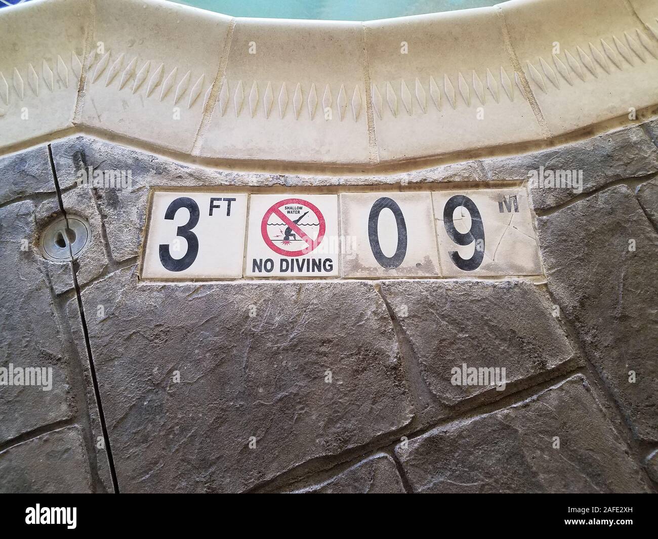 no diving warning sign or symbol at edge of swimming pool Stock Photo ...