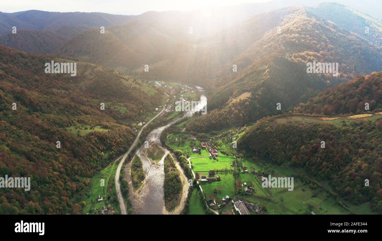picturesque river with bridge connects small villages in valley between ...