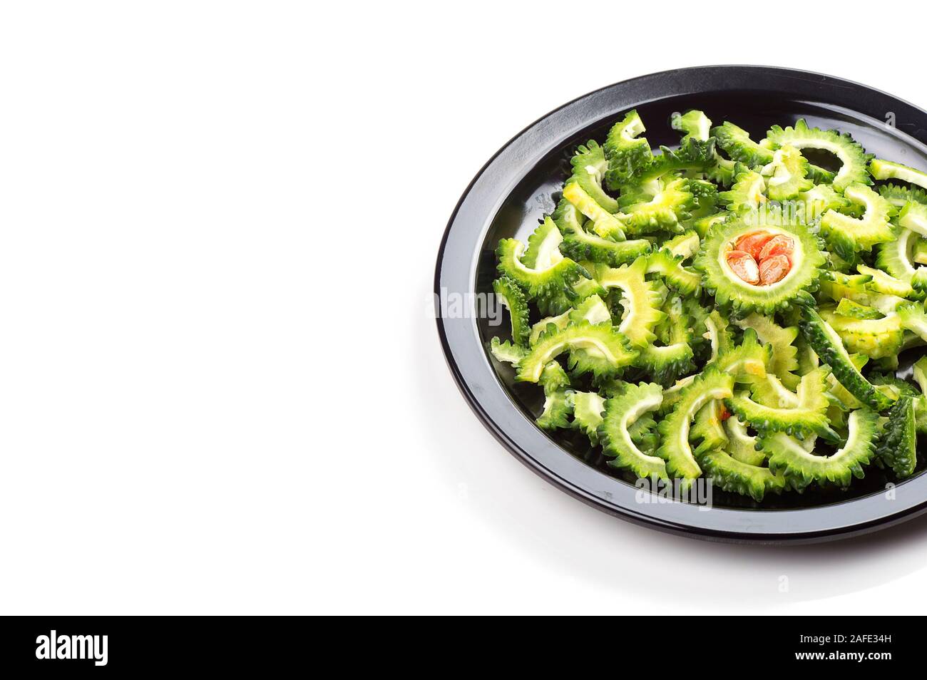 Bitter melon or bitter gourd in black plate on white background Stock ...