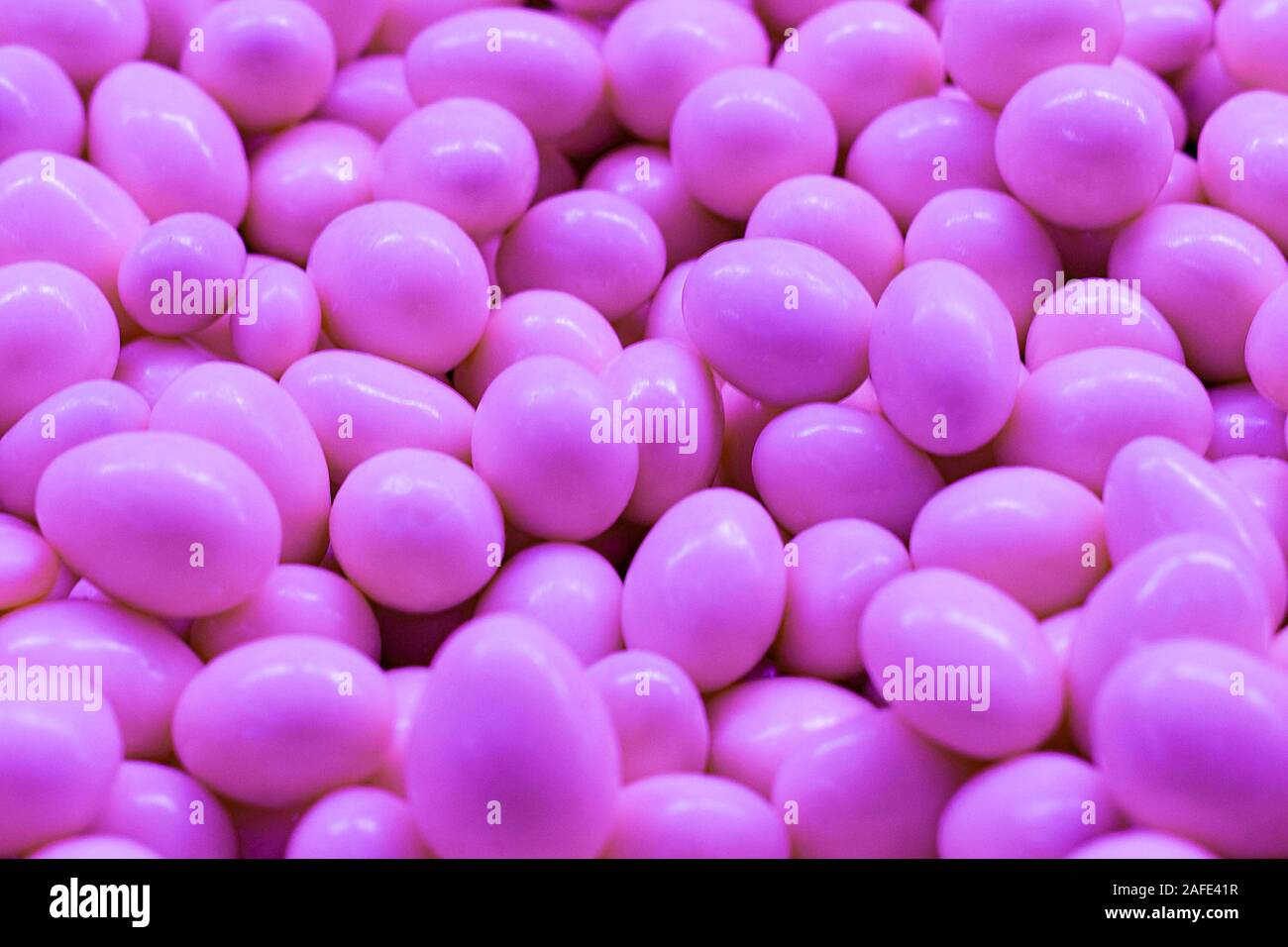 Purple oval sweets - dragee in bulk. Top View Stock Photo - Alamy