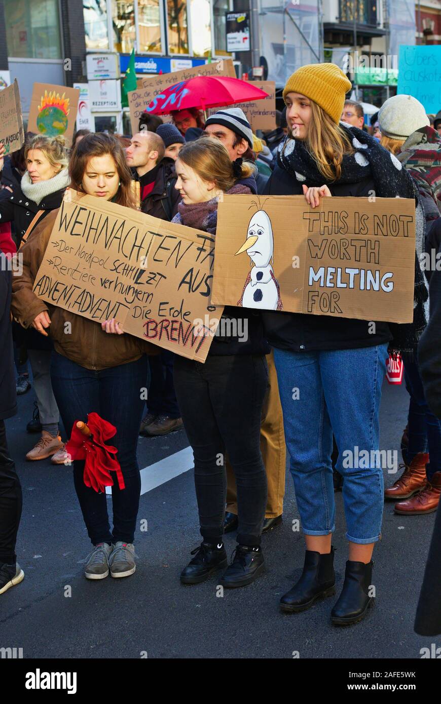 Three female teen school kids carrying climate protest signs on Fridays ...